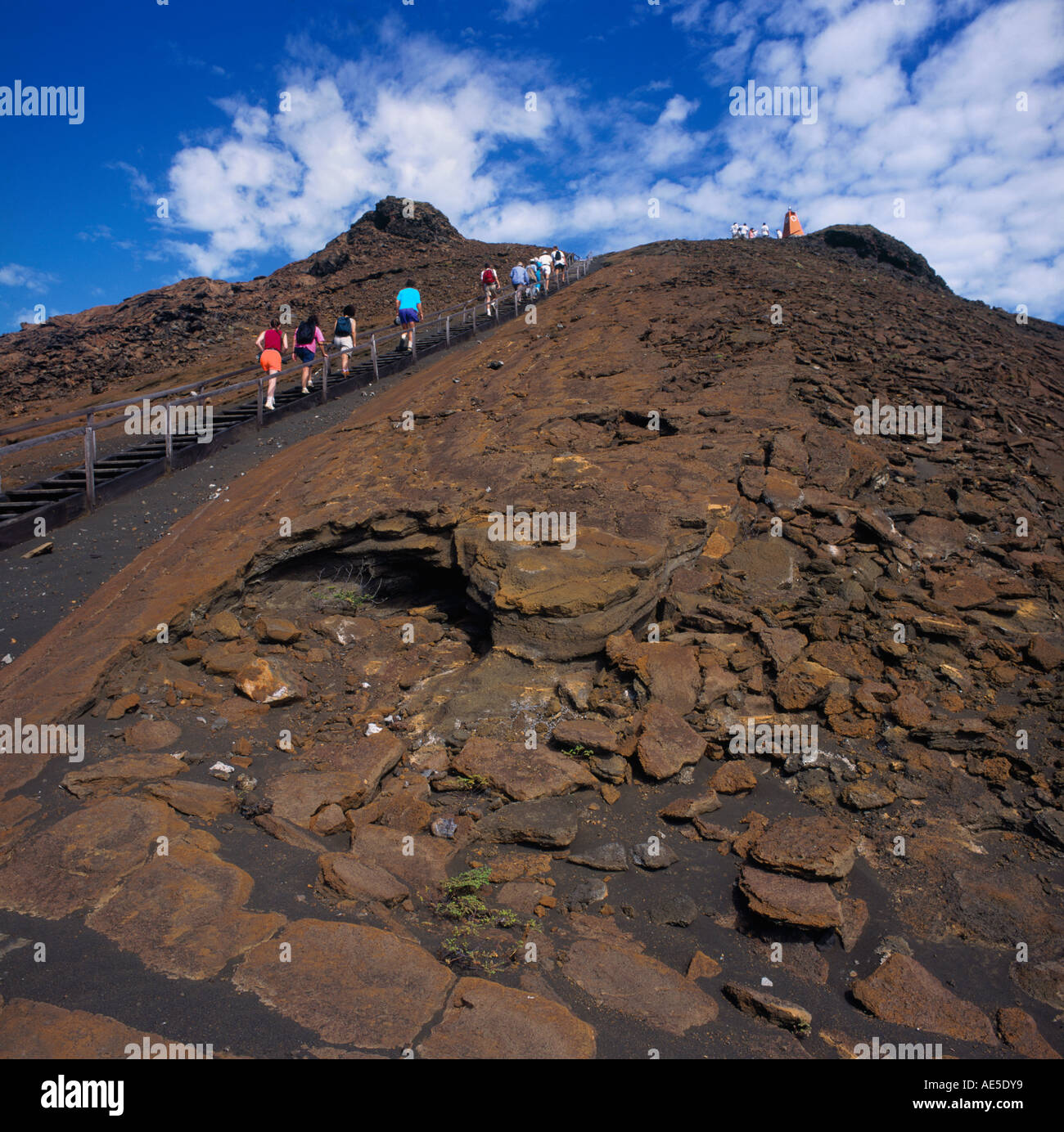 Tourists walking up wooden steps towards summit of volcanic peak on ...