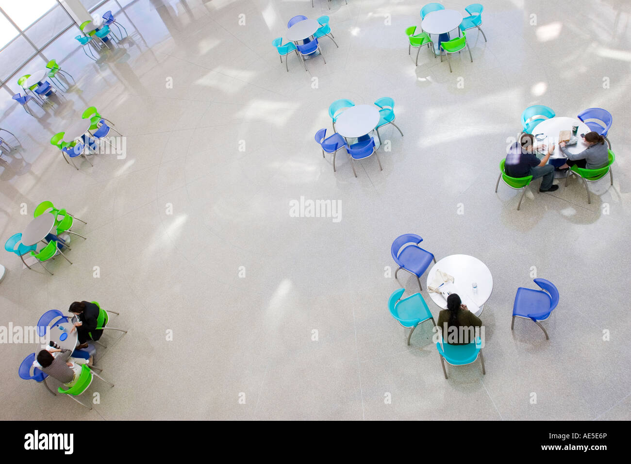 Aerial view of three sets of people sitting at tables and chairs in the ...