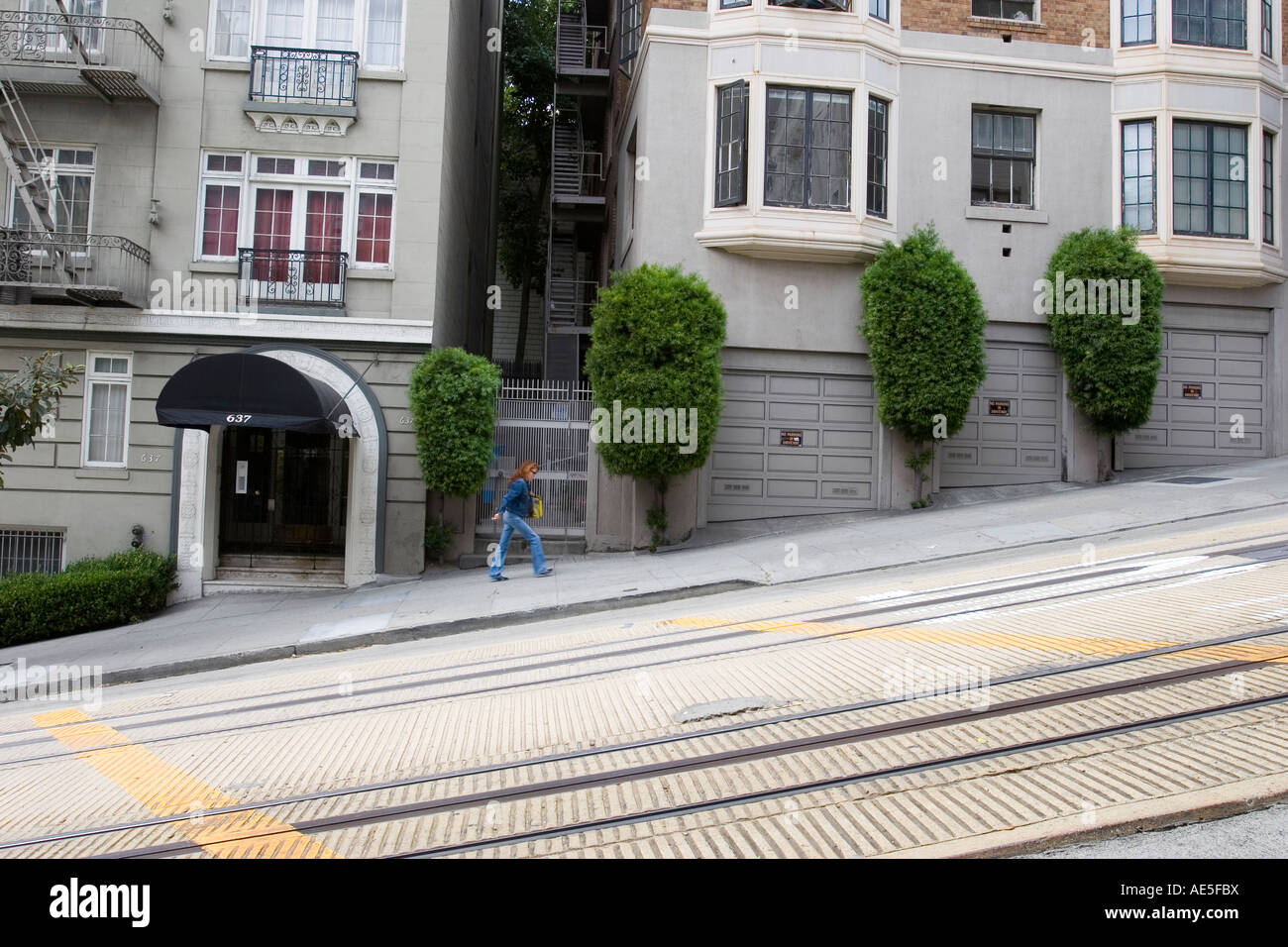 Person walking up steep sloped Powell Street in San Francisco passing ...