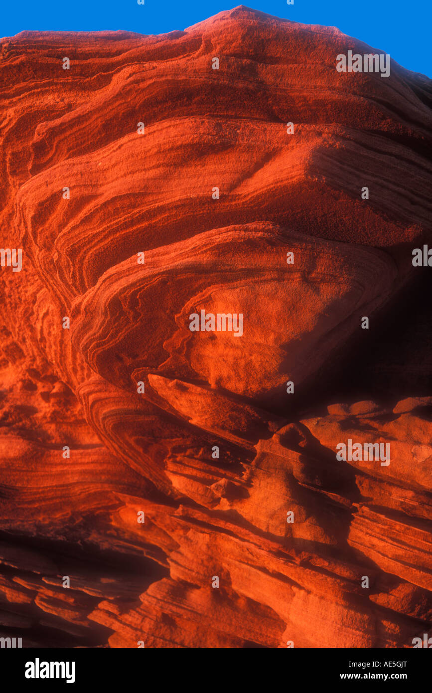 Glowing swirling striated red rock formation in intricate and complex ...