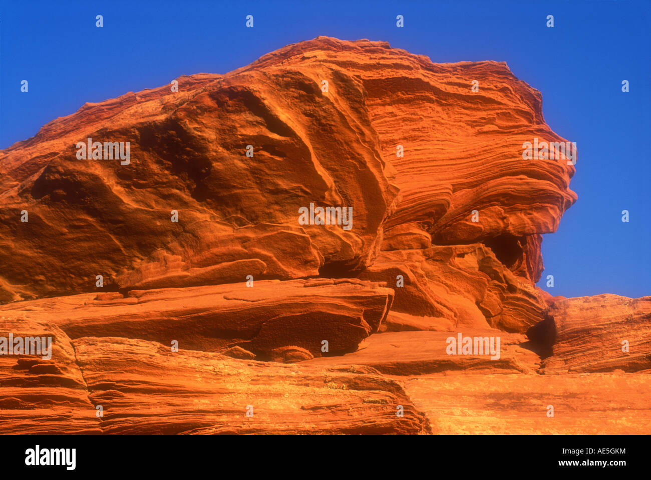 Striated red rock formation in a shape that resembles the side of a ...
