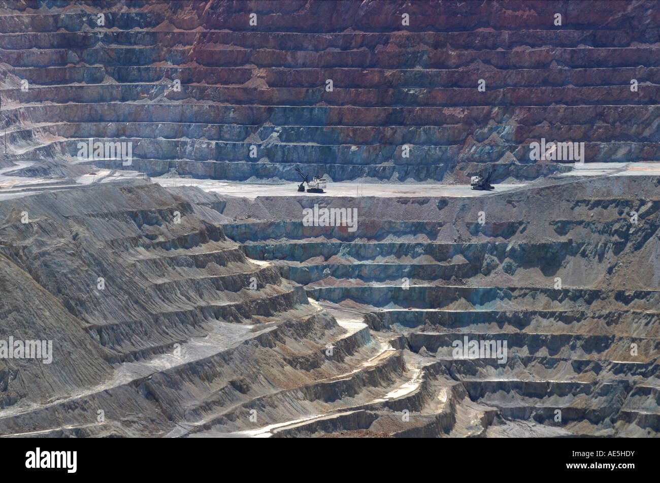 Two giant mining machine look minuscule inside an enormous copper mine ...