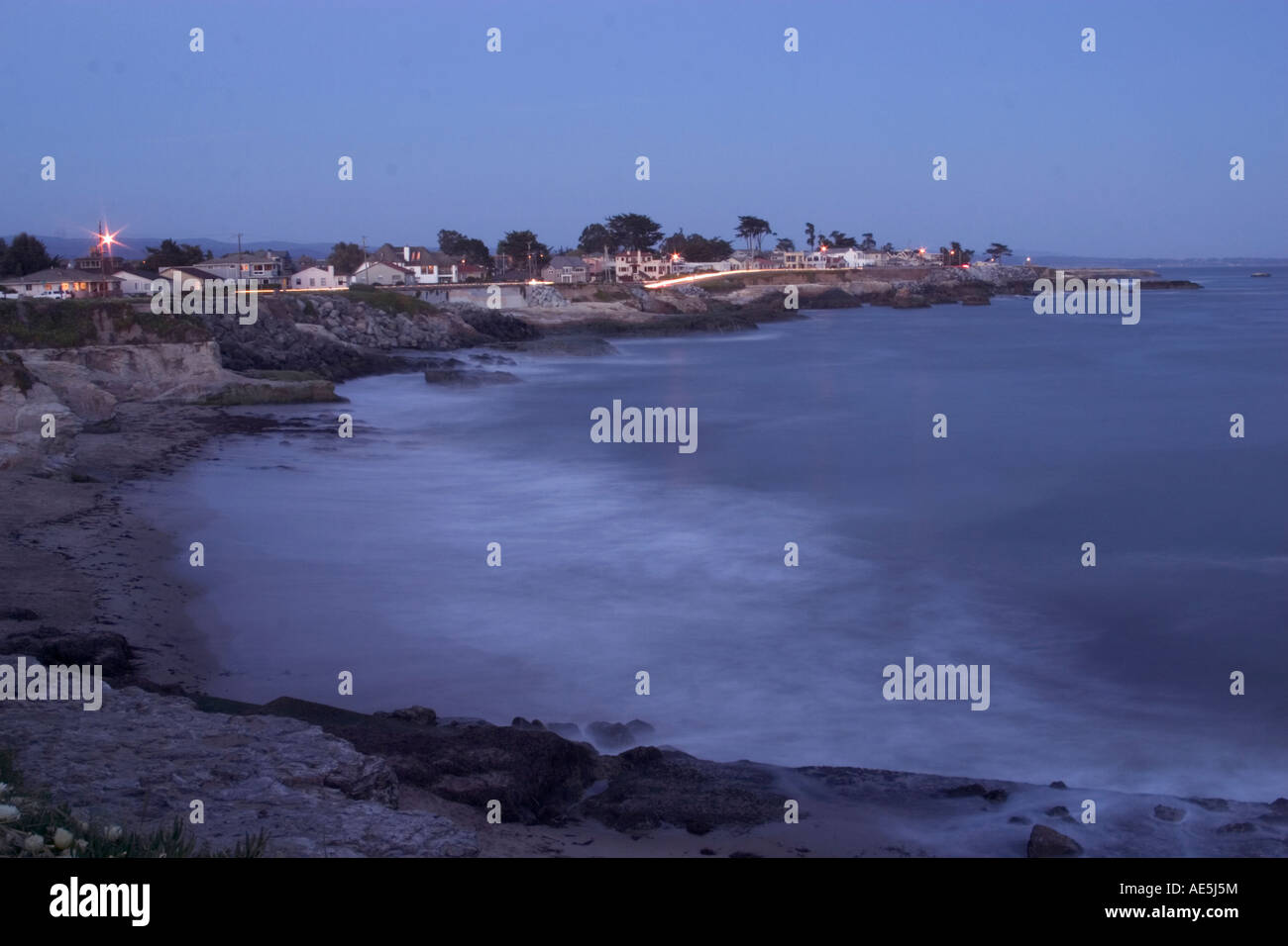 Misty Pacific Ocean beach with cliffs along coastal road at twilight in ...