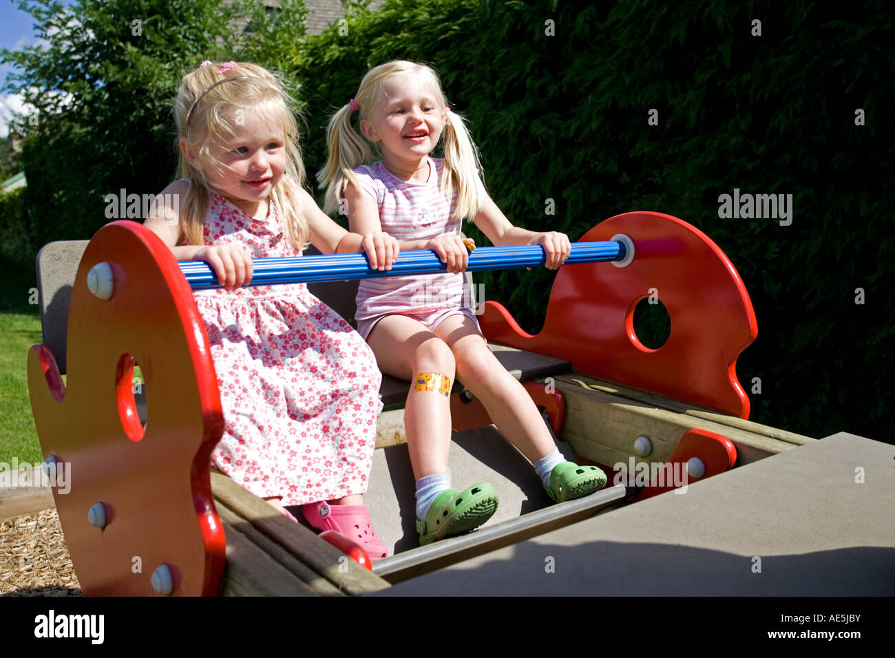 Children playing on seesaw in local playground Woodmancote UK Stock ...