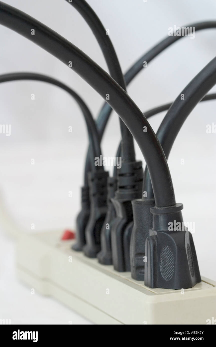 Six power cord plugs filling up a power strip Conveys the concept of ...