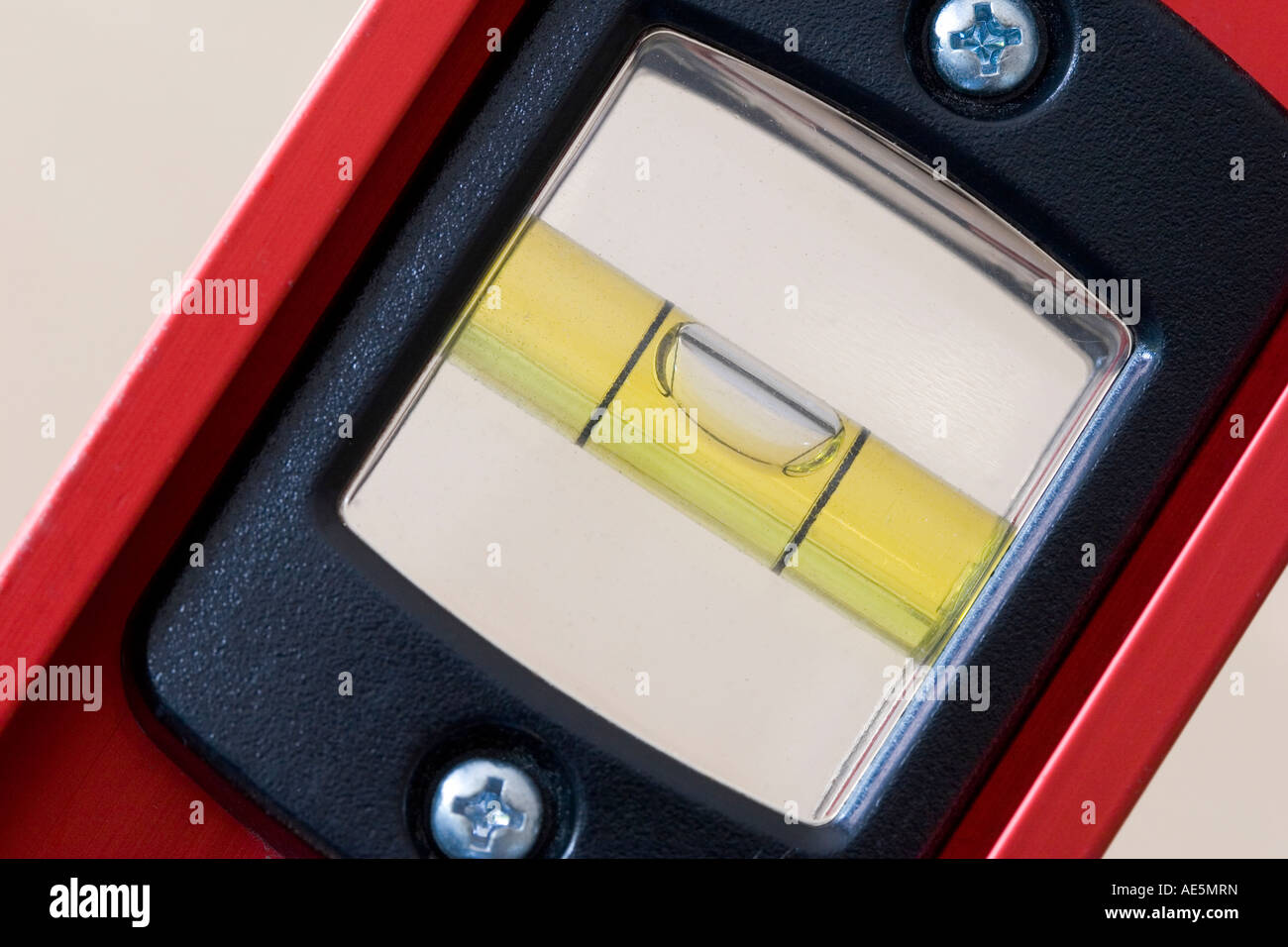 Vertically oriented red metal level tool showing the bubble in the ...