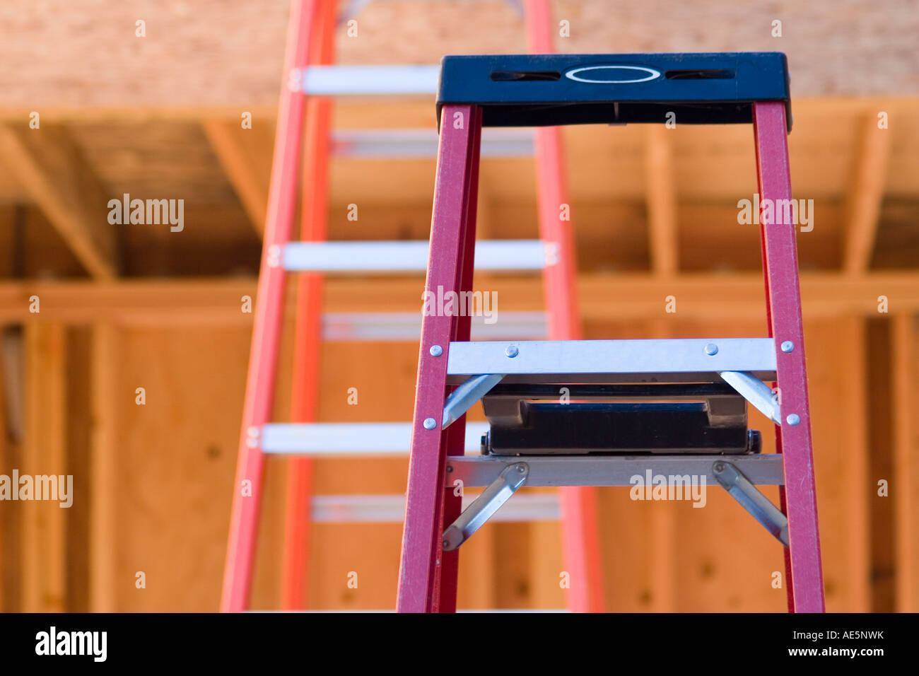 Two ladders at a construction site inside a room being framed as part ...