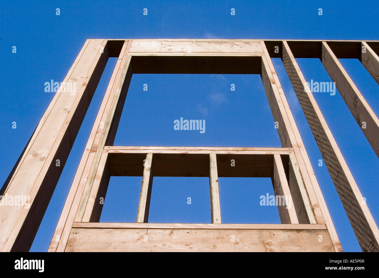 Looking up at a second story window framed in wood through to a clear ...