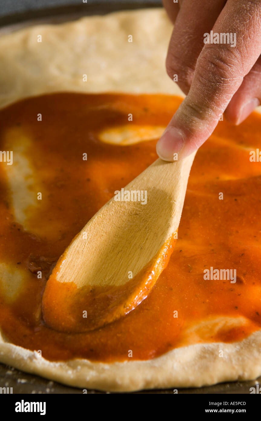 Man spreading pizza sauce Stock Photo - Alamy