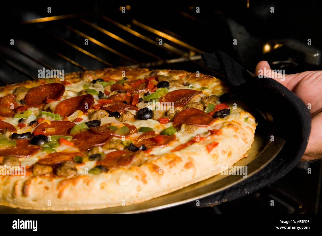 Man taking pizza out oven hi-res stock photography and images - Alamy