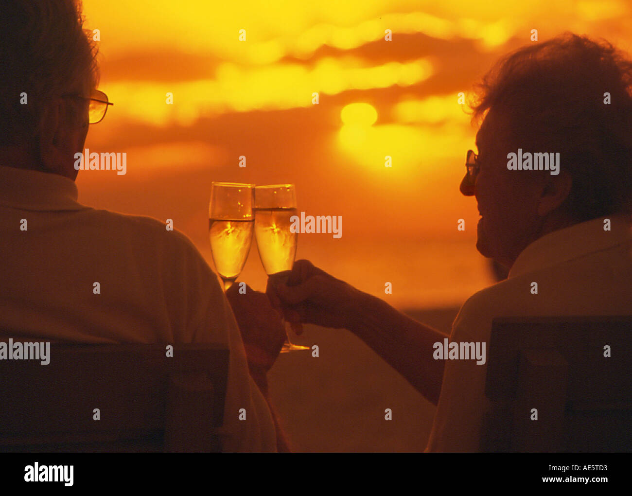 Senior couple toasting at sunset oceanside Stock Photo - Alamy