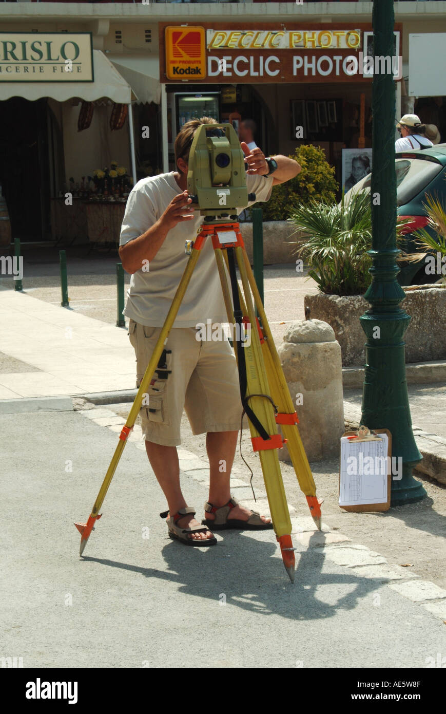 looking into tripod mounted levelling instrument Stock Photo - Alamy