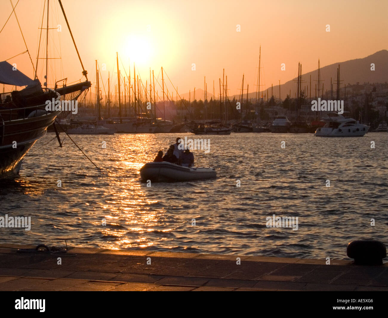 Bodrum Harbour at sunset with incoming dinghy Stock Photo - Alamy