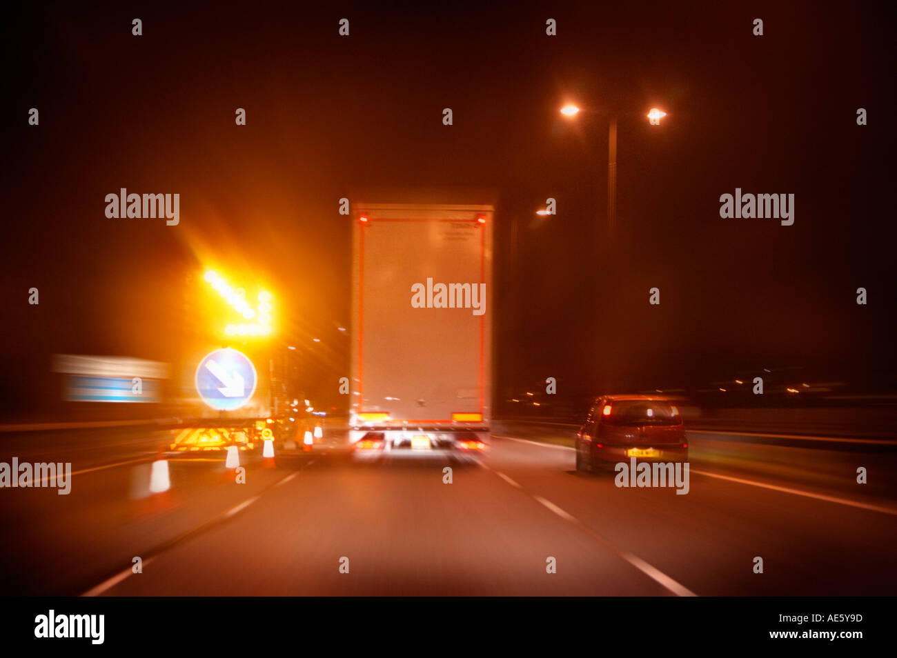 CAR AND TRUCK PASSING MOTORWAY ROADWORKS AT NIGHT Stock Photo - Alamy