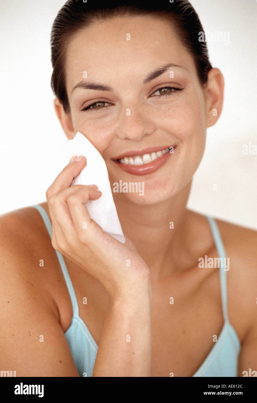 W 19013 06 MODEL RELEASED Female smiling tissue to face removing make ...