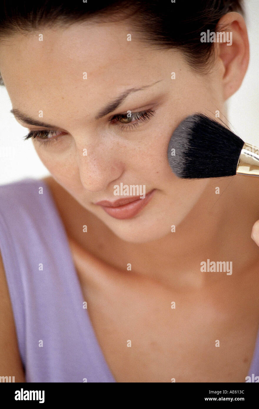 W 19013 40 MODEL RELEASED Female applying loose face powder with brush ...