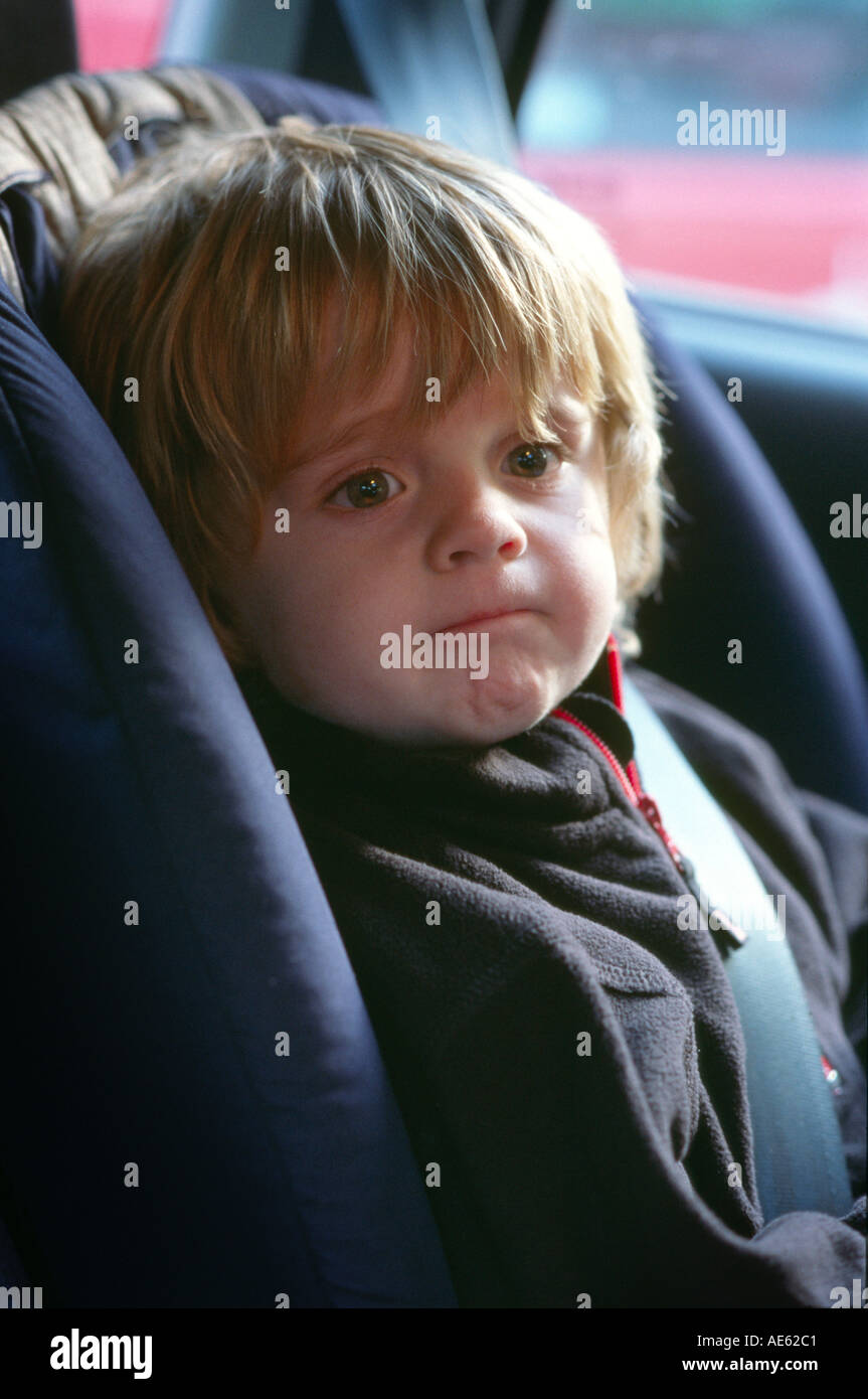 boy in safety child restraining seat in back of car Stock Photo - Alamy