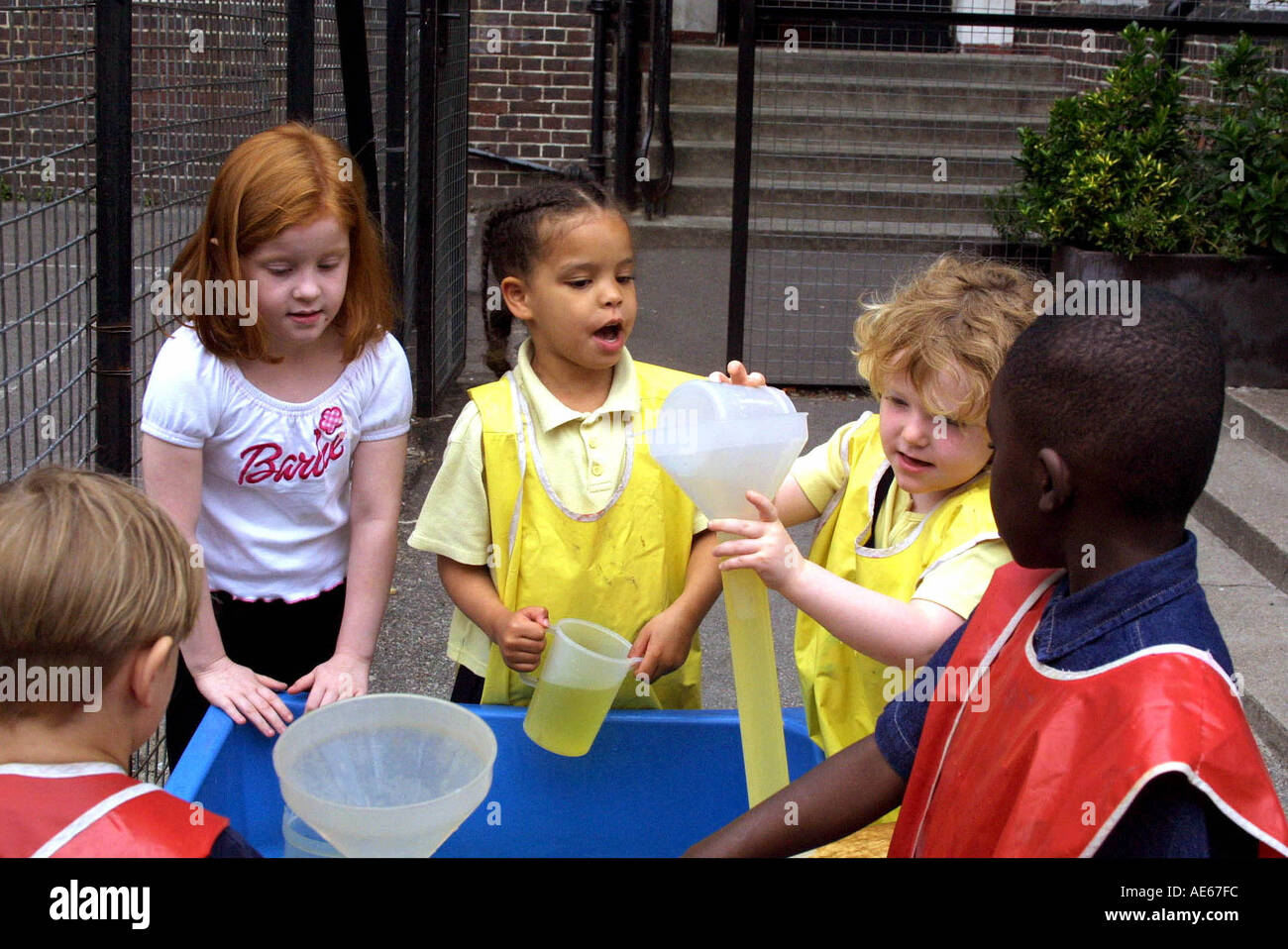 reception kids in playground playing with water Stock Photo - Alamy