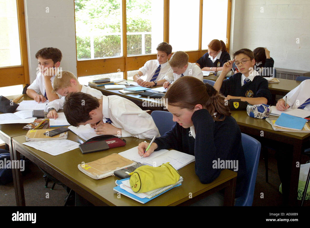 Junior school children in classroom writing Stock Photo - Alamy