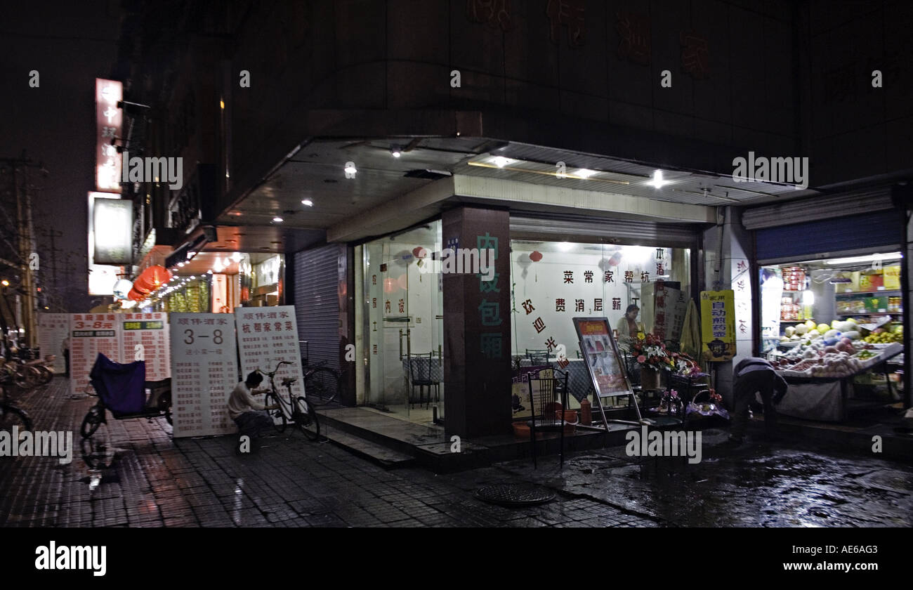 CHINA HANGZHOU Night street scene outside tiny but busy neighborhood ...