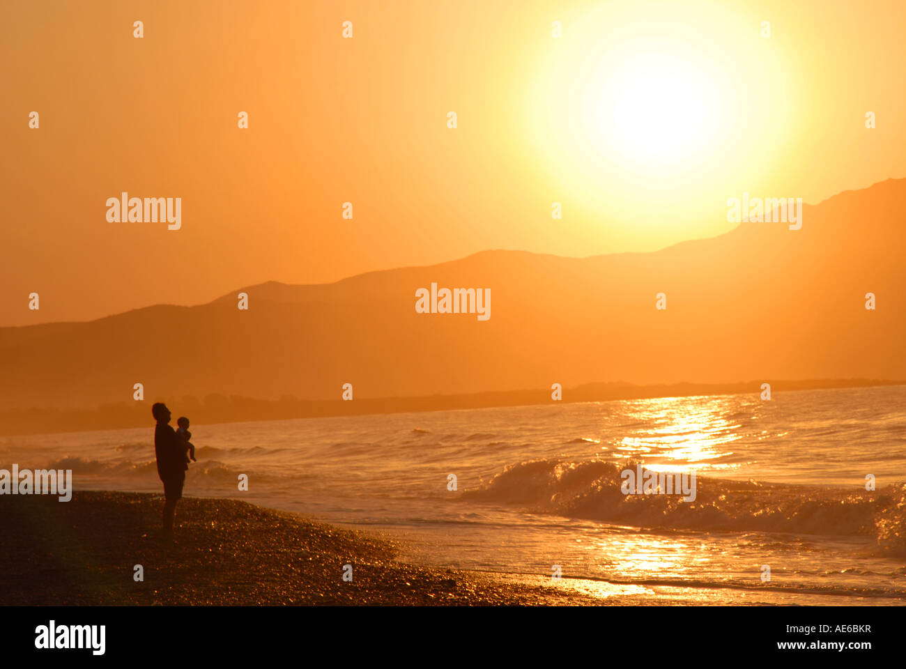 Father holding baby in beach at sunset hi-res stock photography and ...