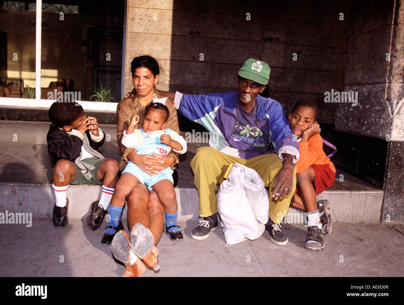 Poor Cuban family seating on a sidewalk in Havana Cuba Waiting for the ...