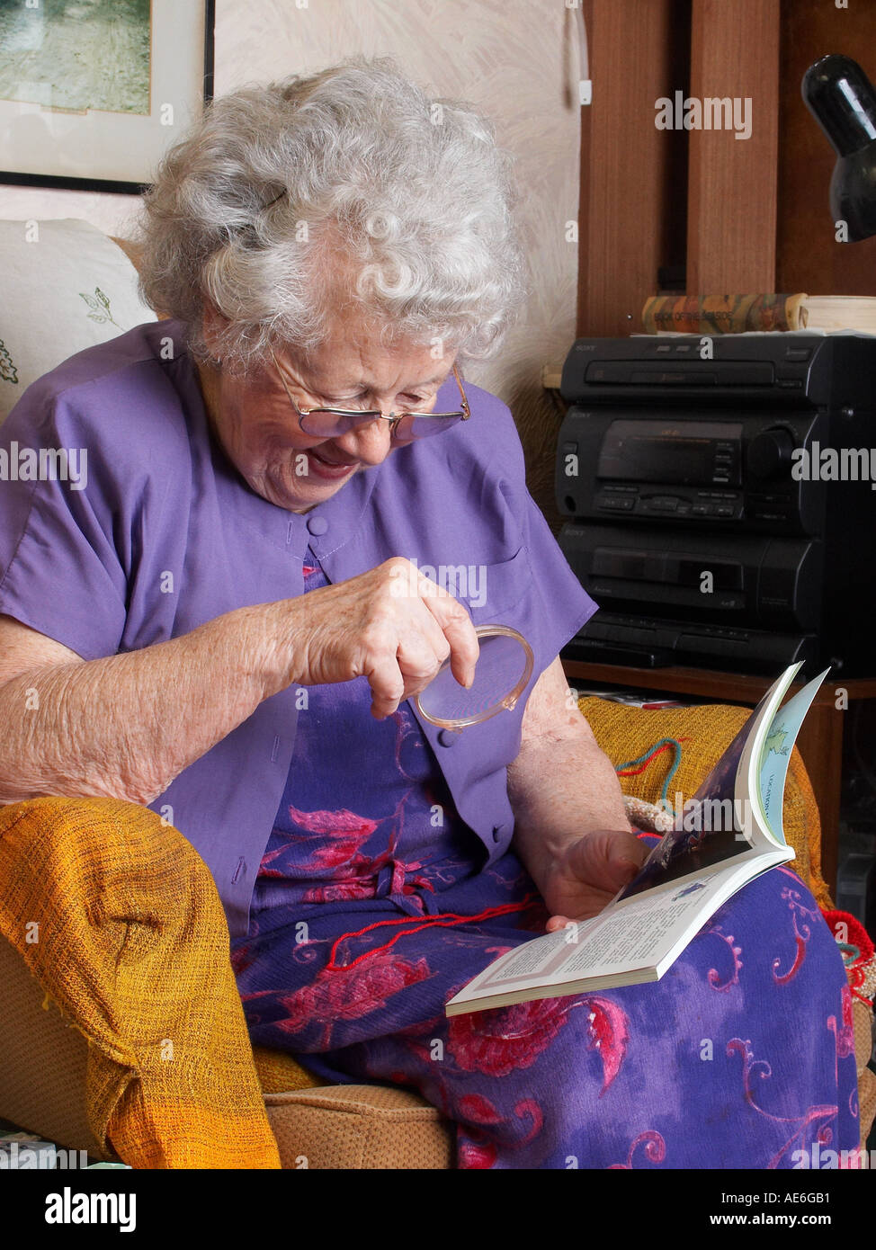 An English lady enjoying retirement using a Magnifing glass to read a ...