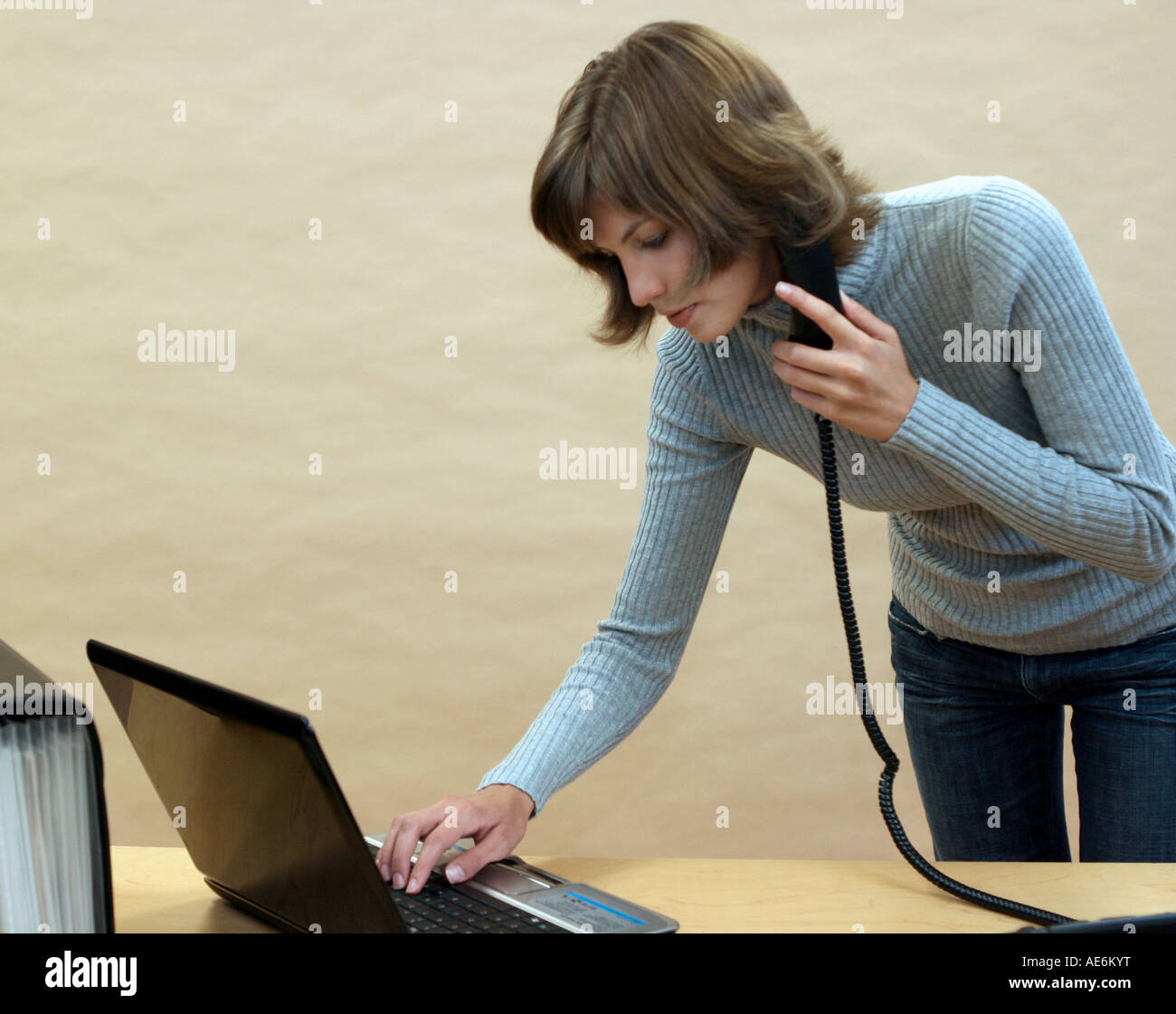 A beautiful young woman standing and working at her desk Stock Photo ...