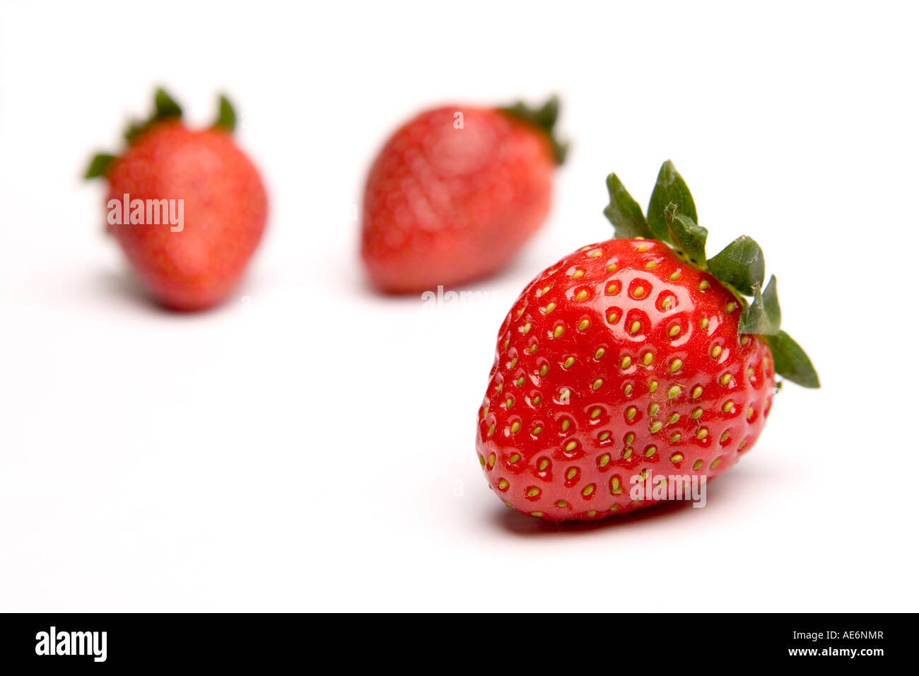 Three strawberries on a white background Stock Photo - Alamy