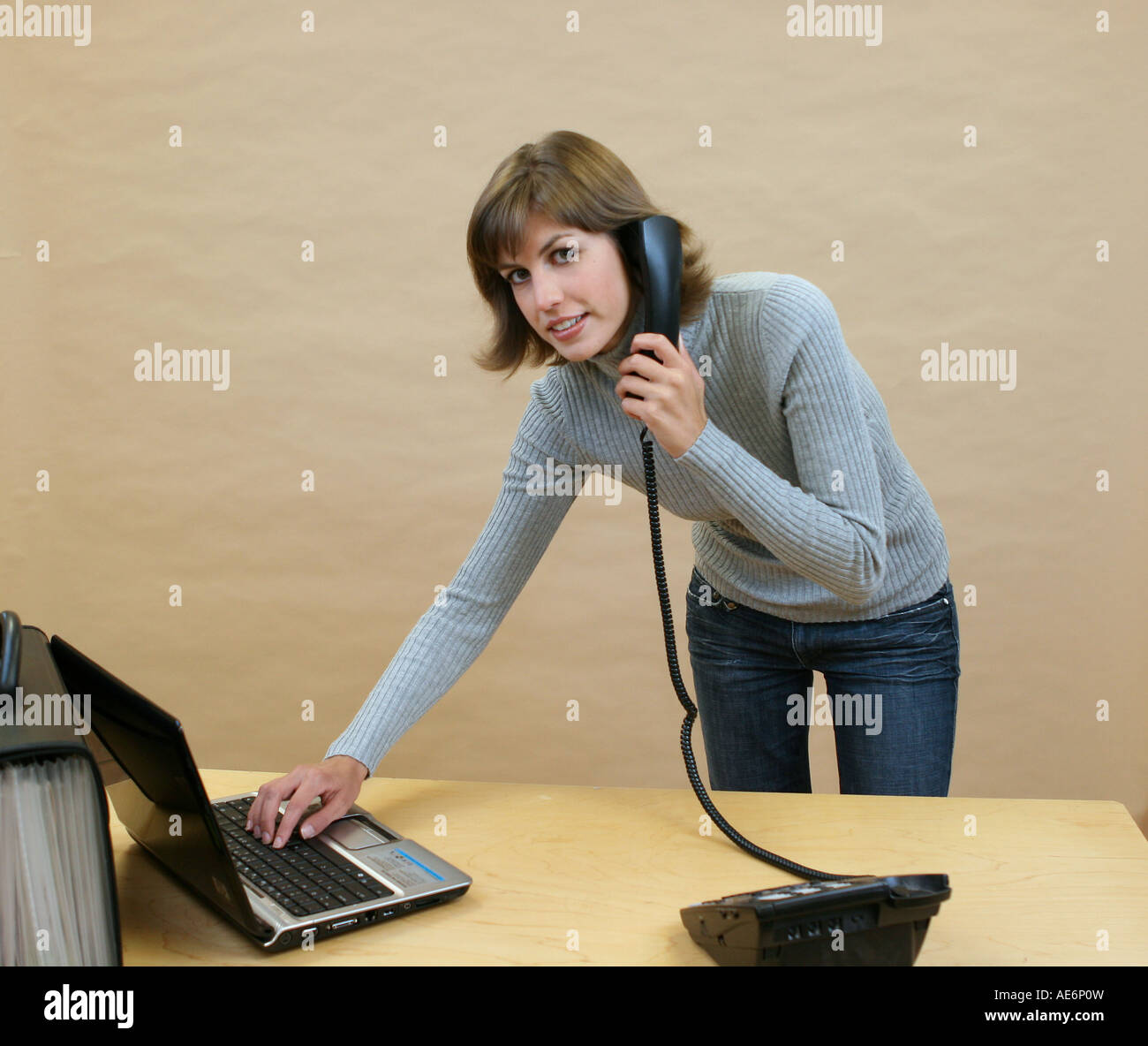 A beautiful young woman standing and working at her desk Stock Photo ...