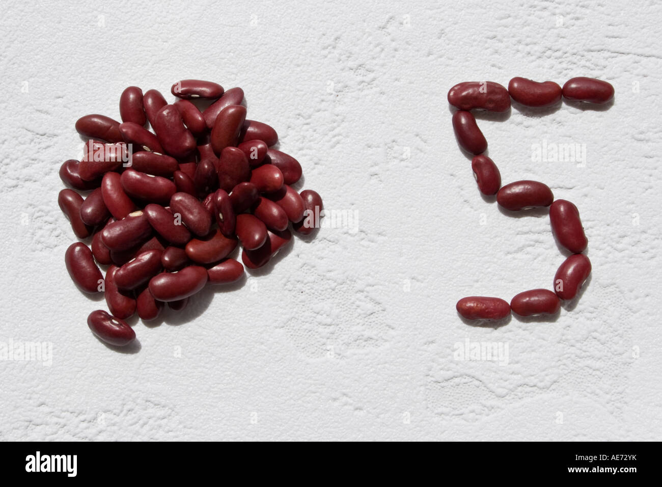Pile of beans and beans arranged in the shape of five isolated on white ...