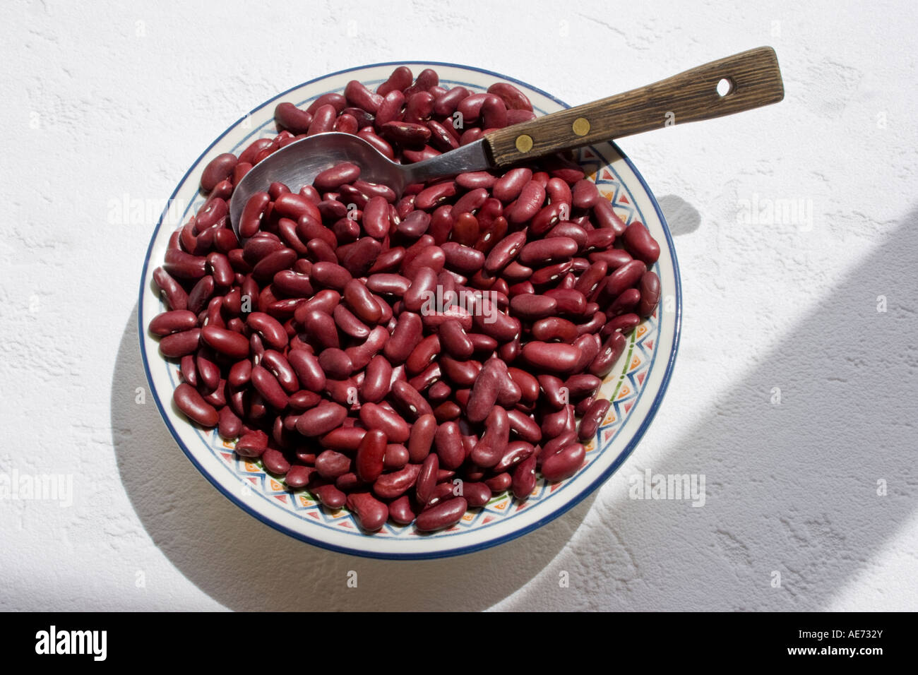 Overhead view of red Kidney beans in bowl with spoon with wooden handle ...