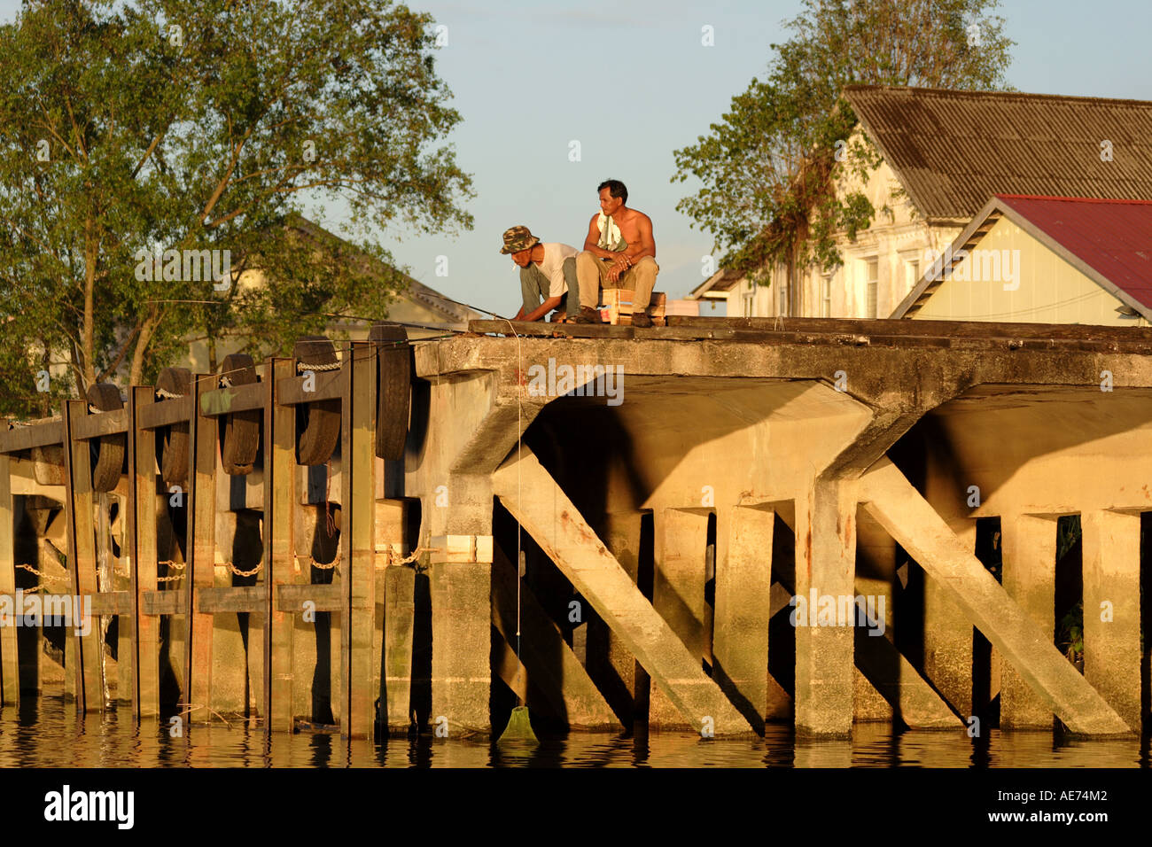 Two Malaysian Men Fishing Off of a Dock at Sunset, Kuching, Sarawak ...