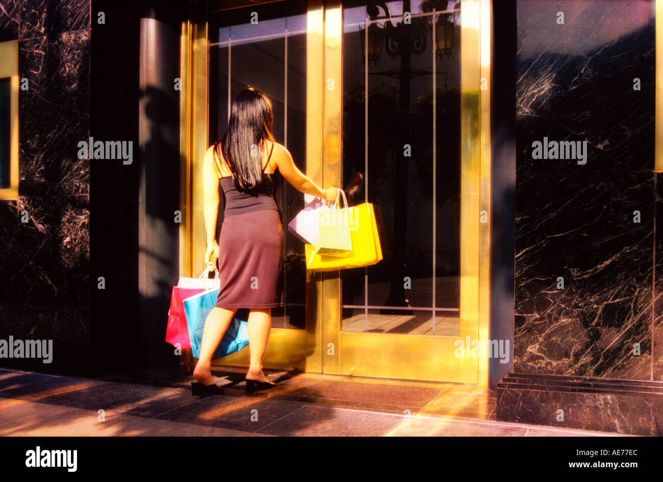 Woman carrying shopping bags about to enter store Beverly Hills CA USA ...