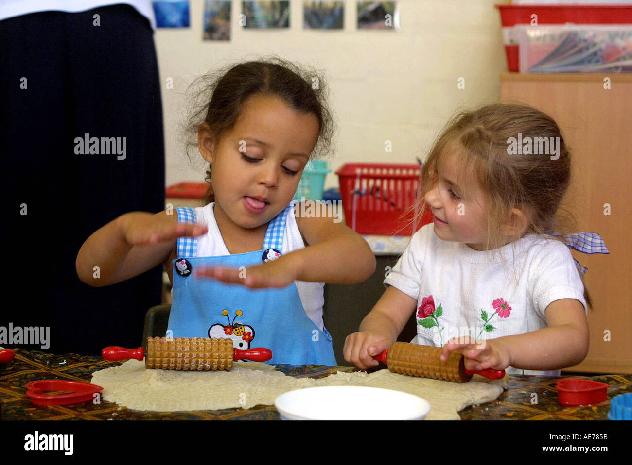 Nursery school girls rolling pastry Stock Photo - Alamy