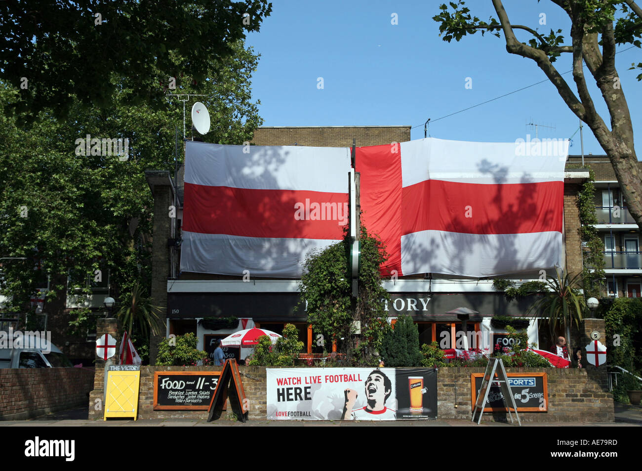 Giant England Flag shrouds a pub in England during the soccer football ...