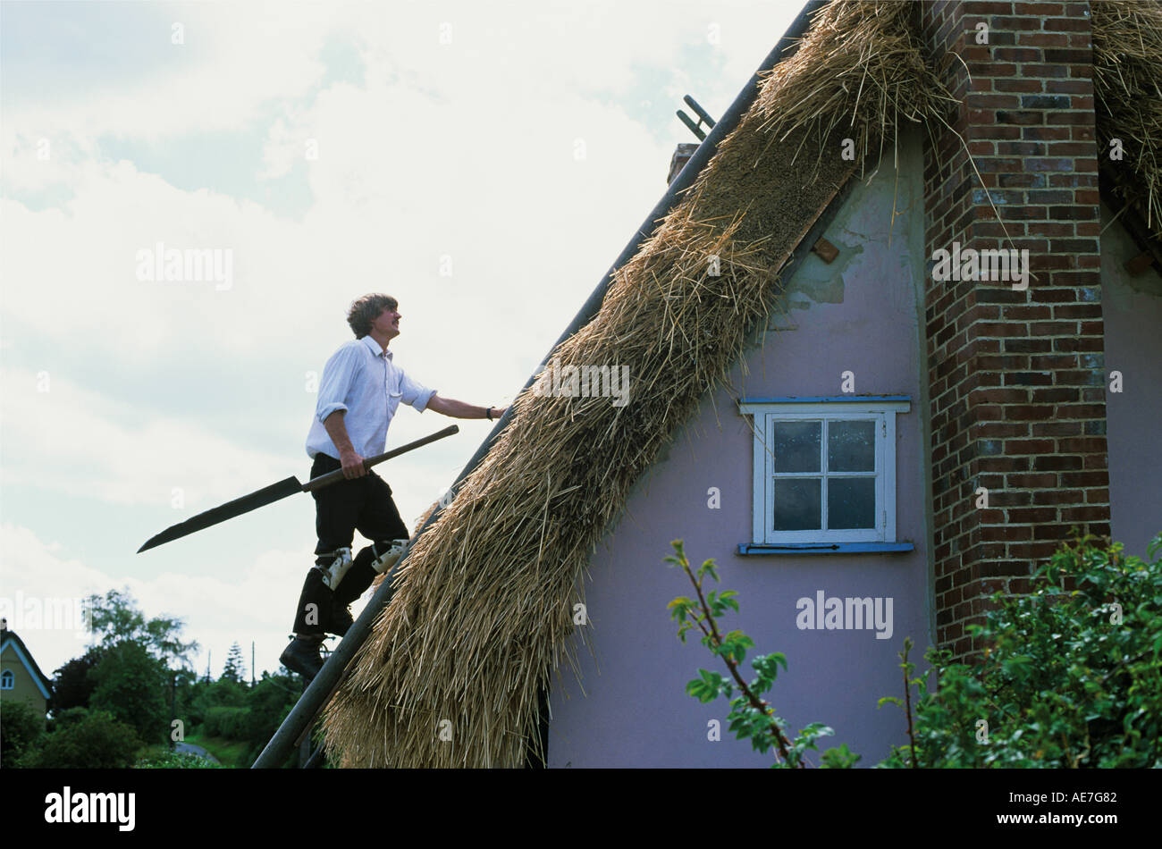Traditional thatch roof nearing completion Huge sharp knife is used to ...
