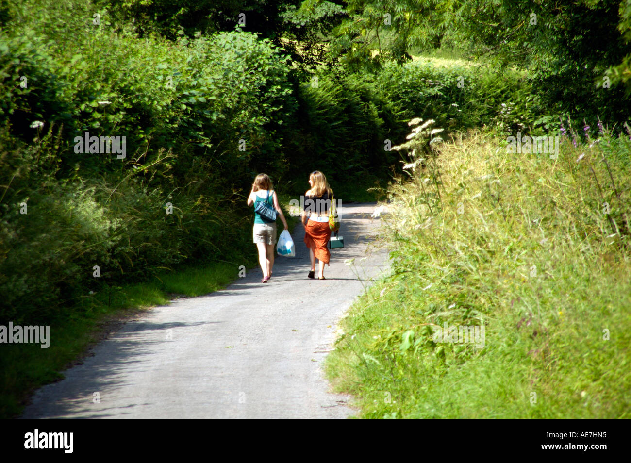 Woman walking down country lane hi-res stock photography and images - Alamy