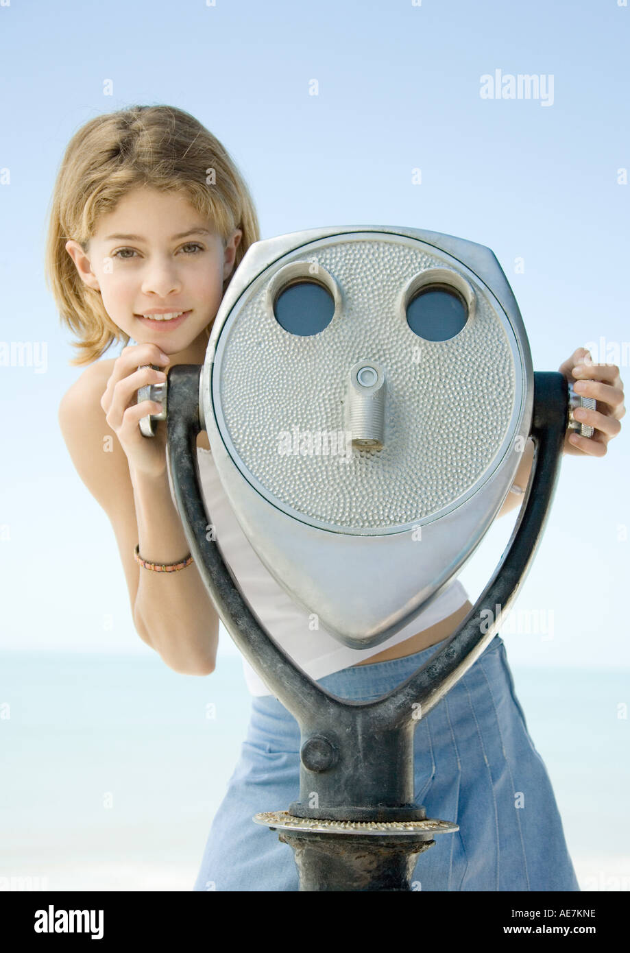Girl looking from behind pay binoculars Stock Photo - Alamy