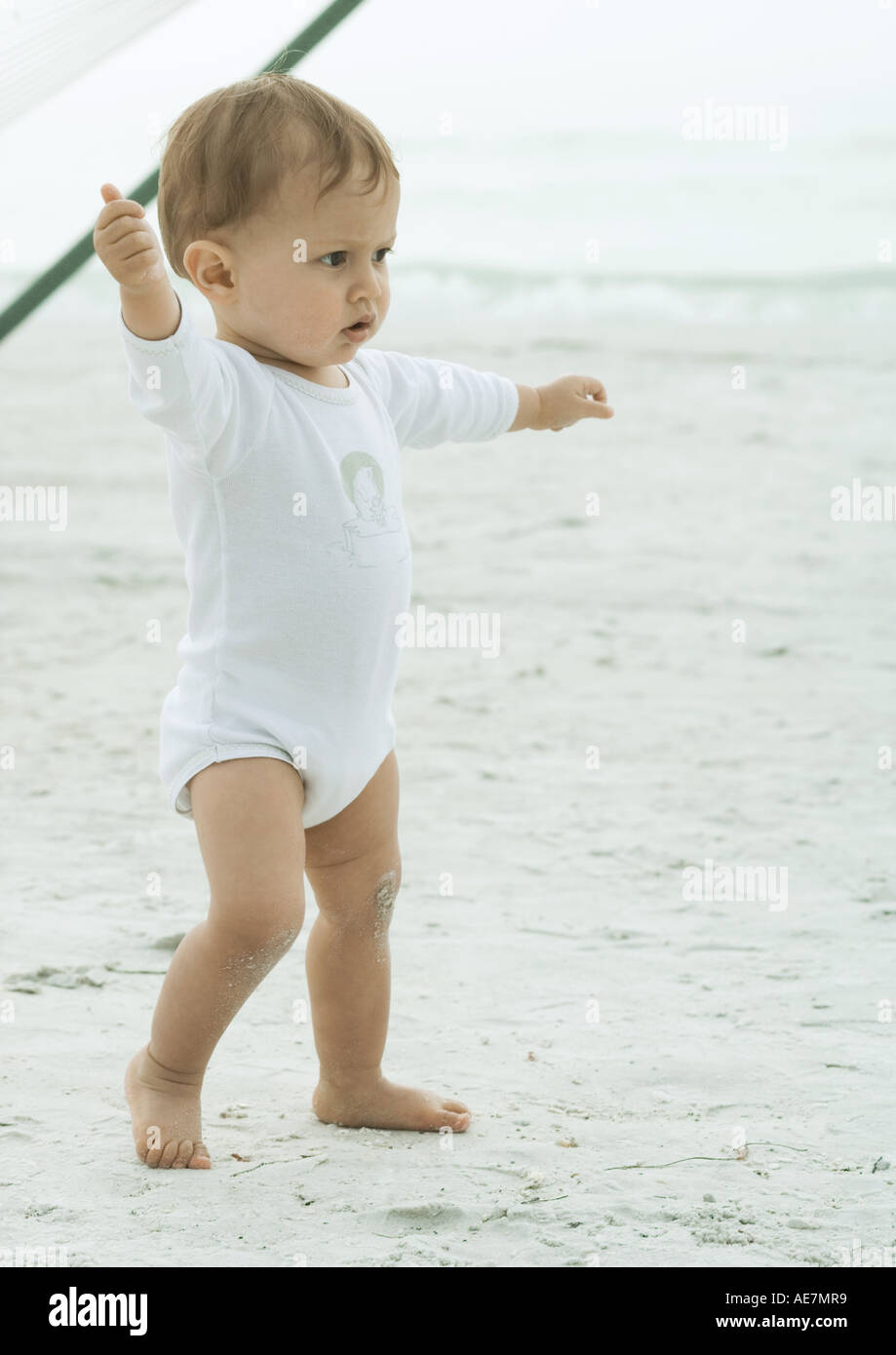 Baby walking on beach with arms outstretched Stock Photo - Alamy