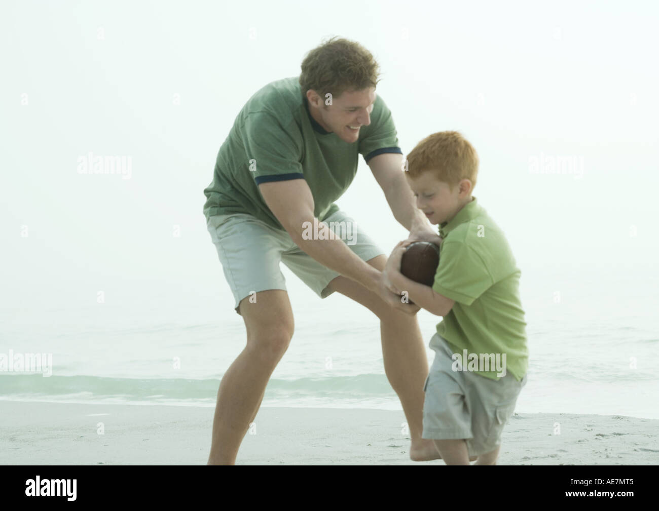 Father and son fighting for ball on beach Stock Photo - Alamy