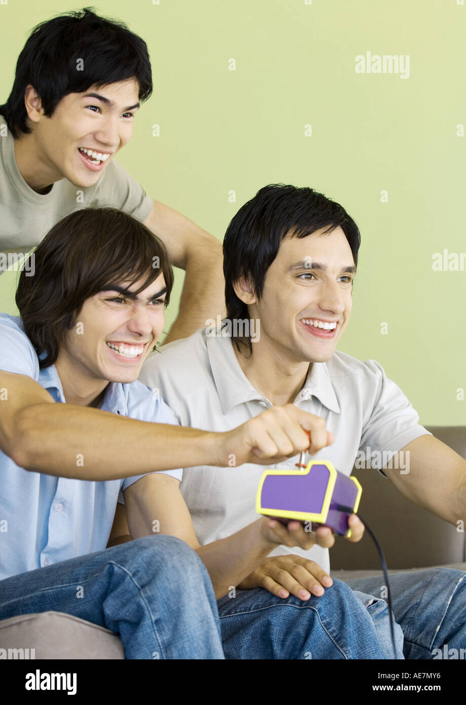 Three young men playing video games Stock Photo - Alamy