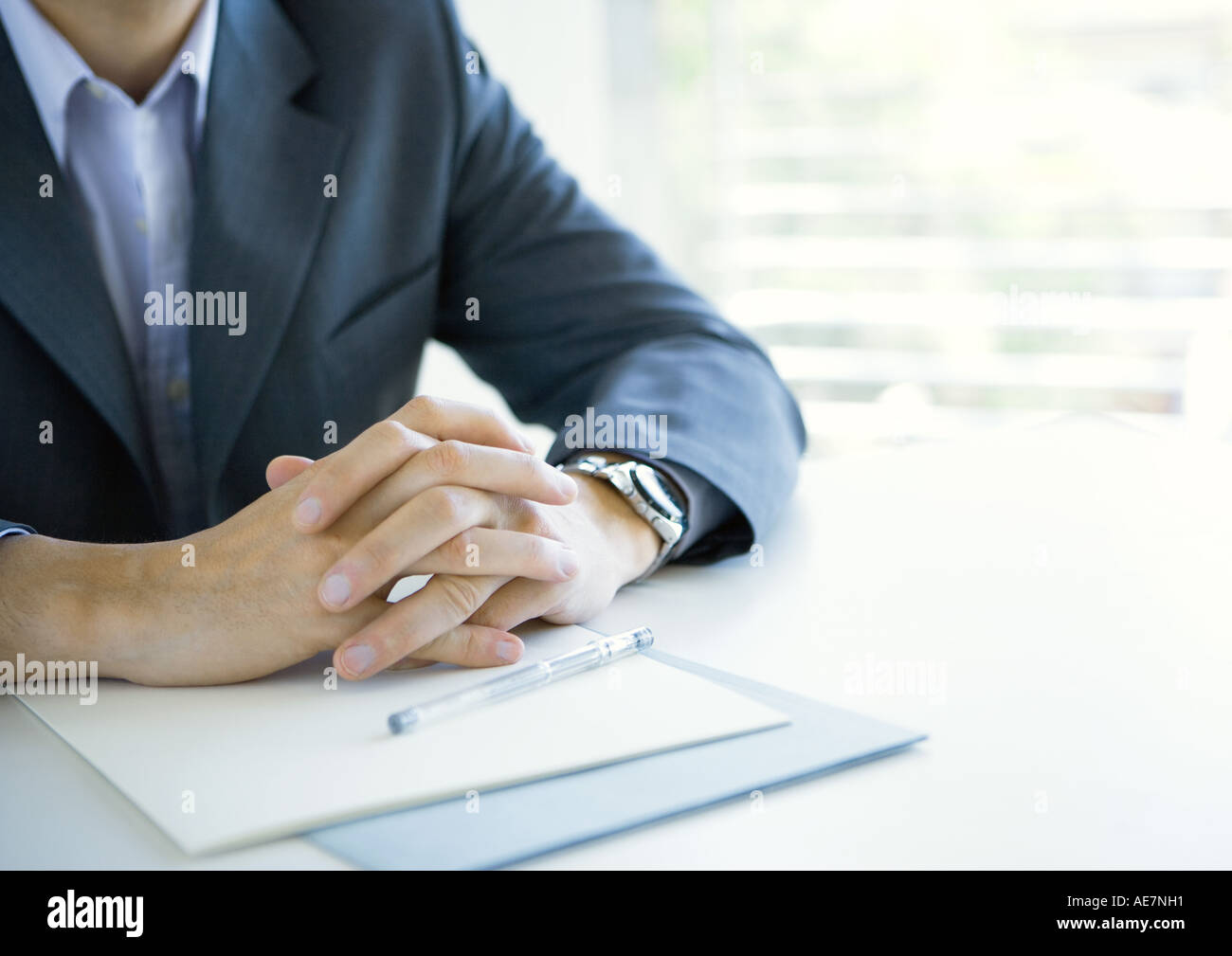Businessman clasping hands on desk, cropped Stock Photo - Alamy