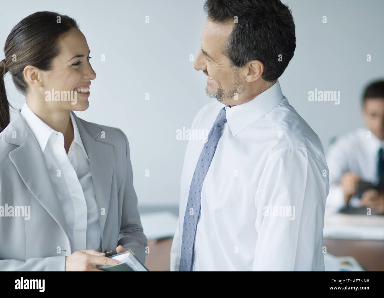 Two business colleagues smiling at each other Stock Photo - Alamy