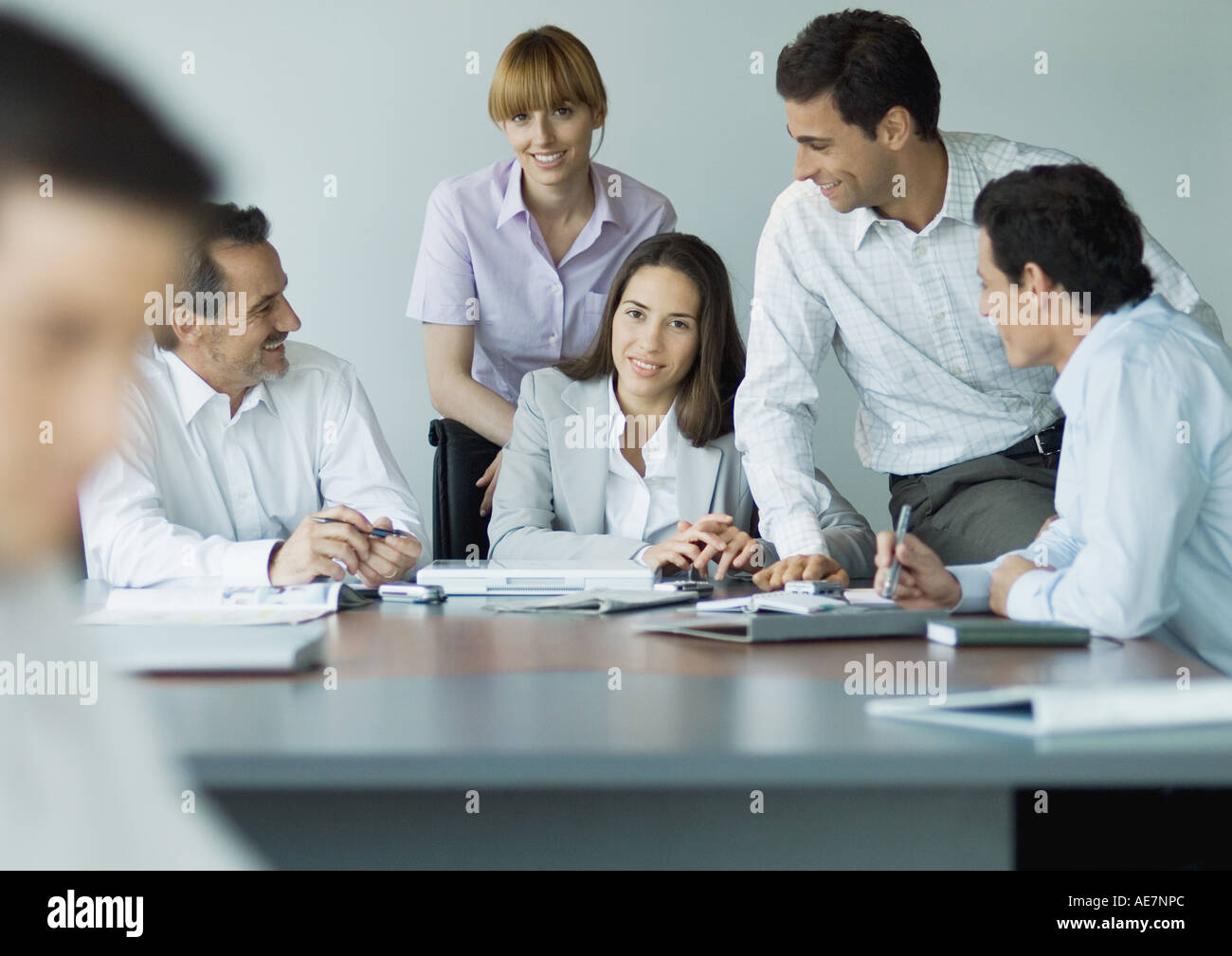 Business colleagues gathered around table, smiling Stock Photo - Alamy