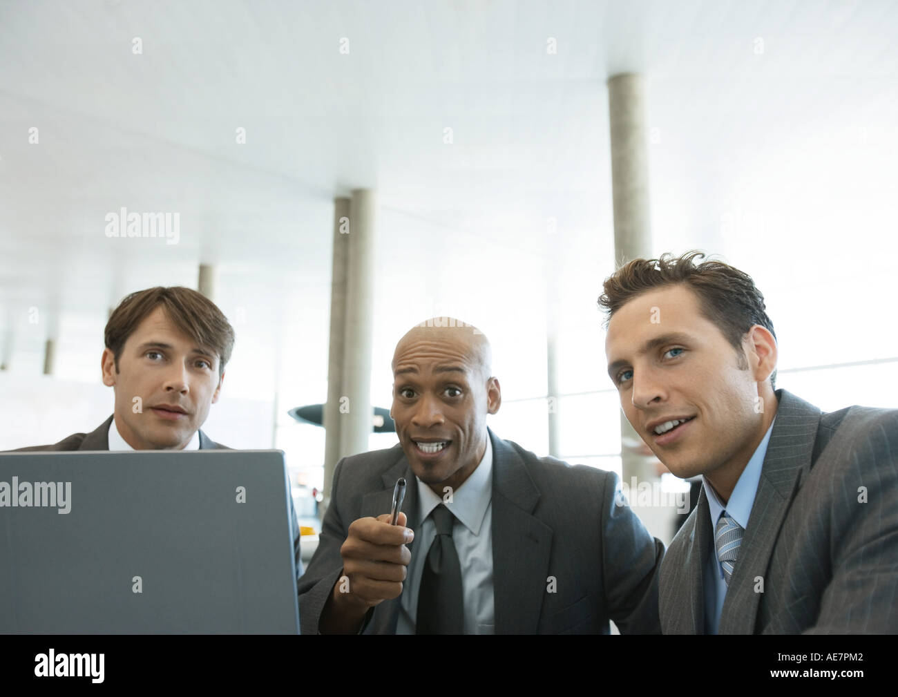 Three businessmen talking in airport Stock Photo - Alamy