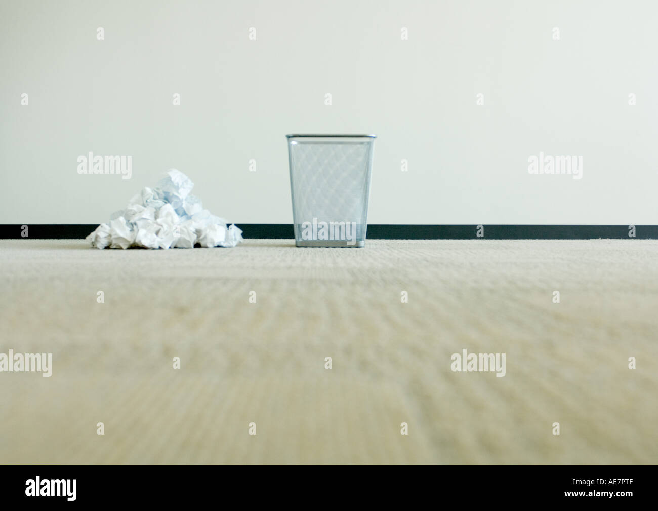Pile of crumpled paper next to empty wastebasket Stock Photo - Alamy