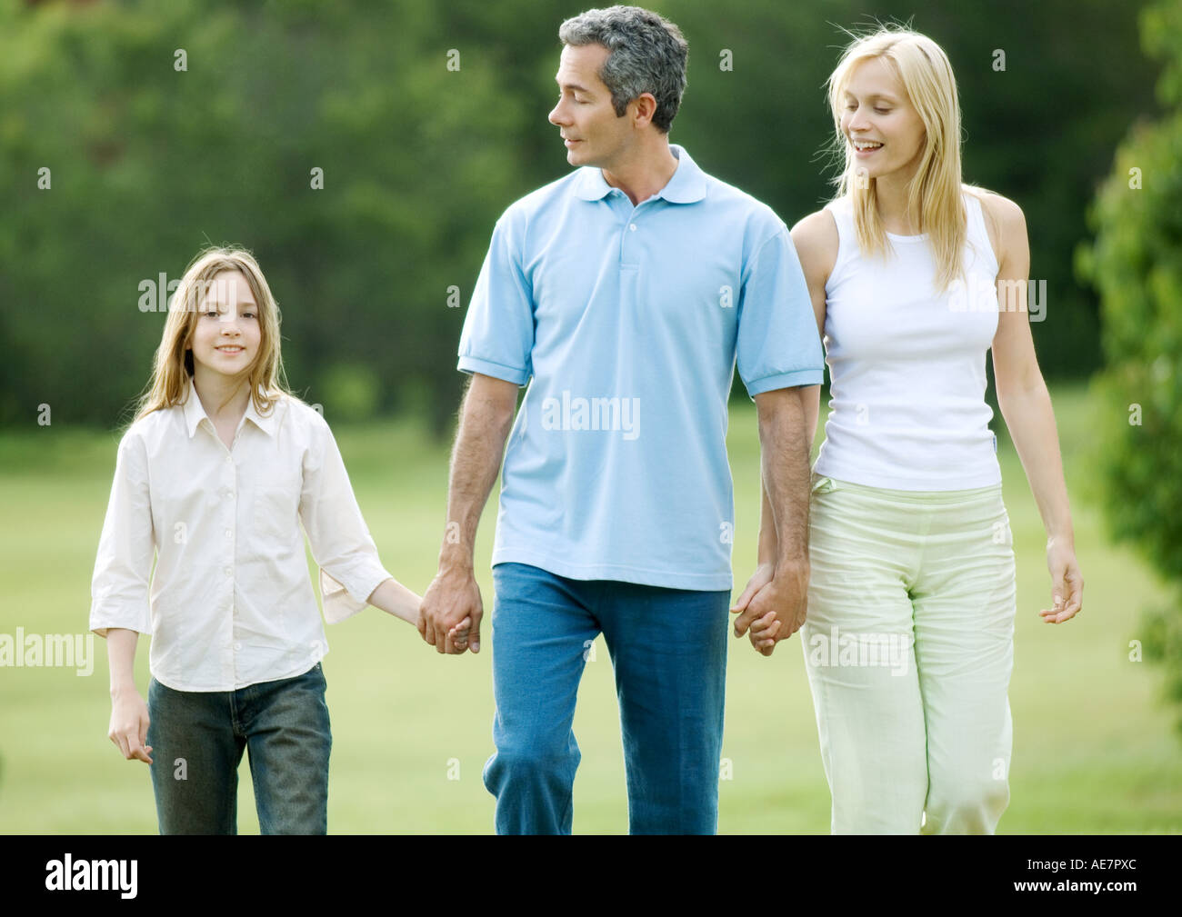 Girl taking walk with parents Stock Photo - Alamy