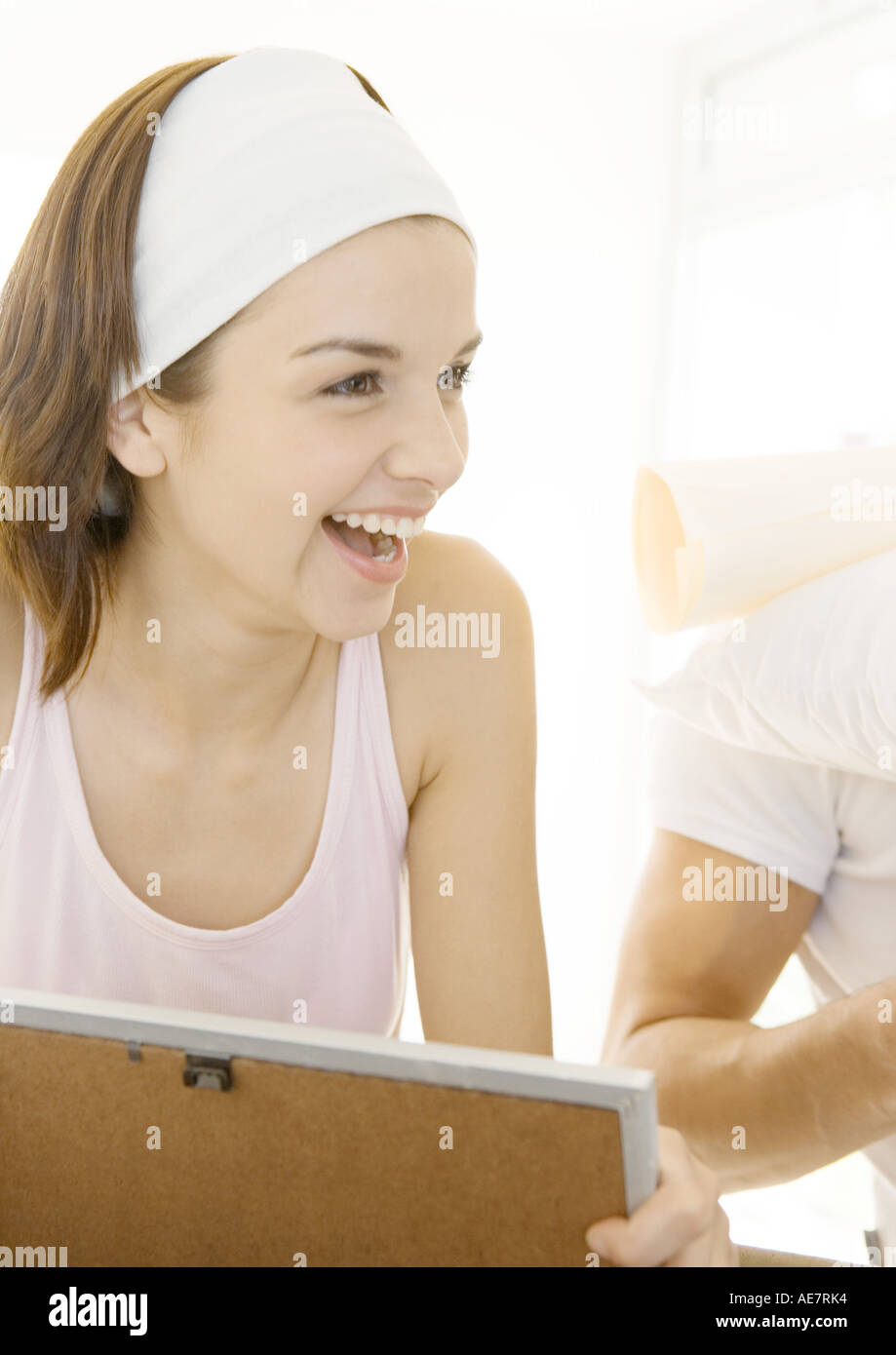 Woman holding frame, laughing Stock Photo - Alamy