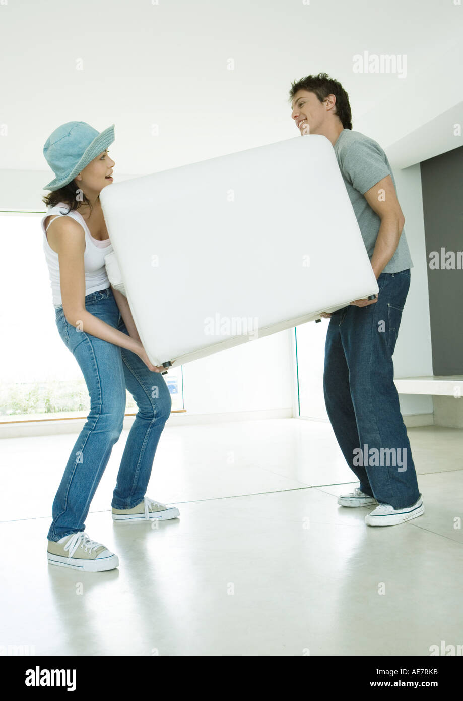 Couple moving armchair together Stock Photo - Alamy